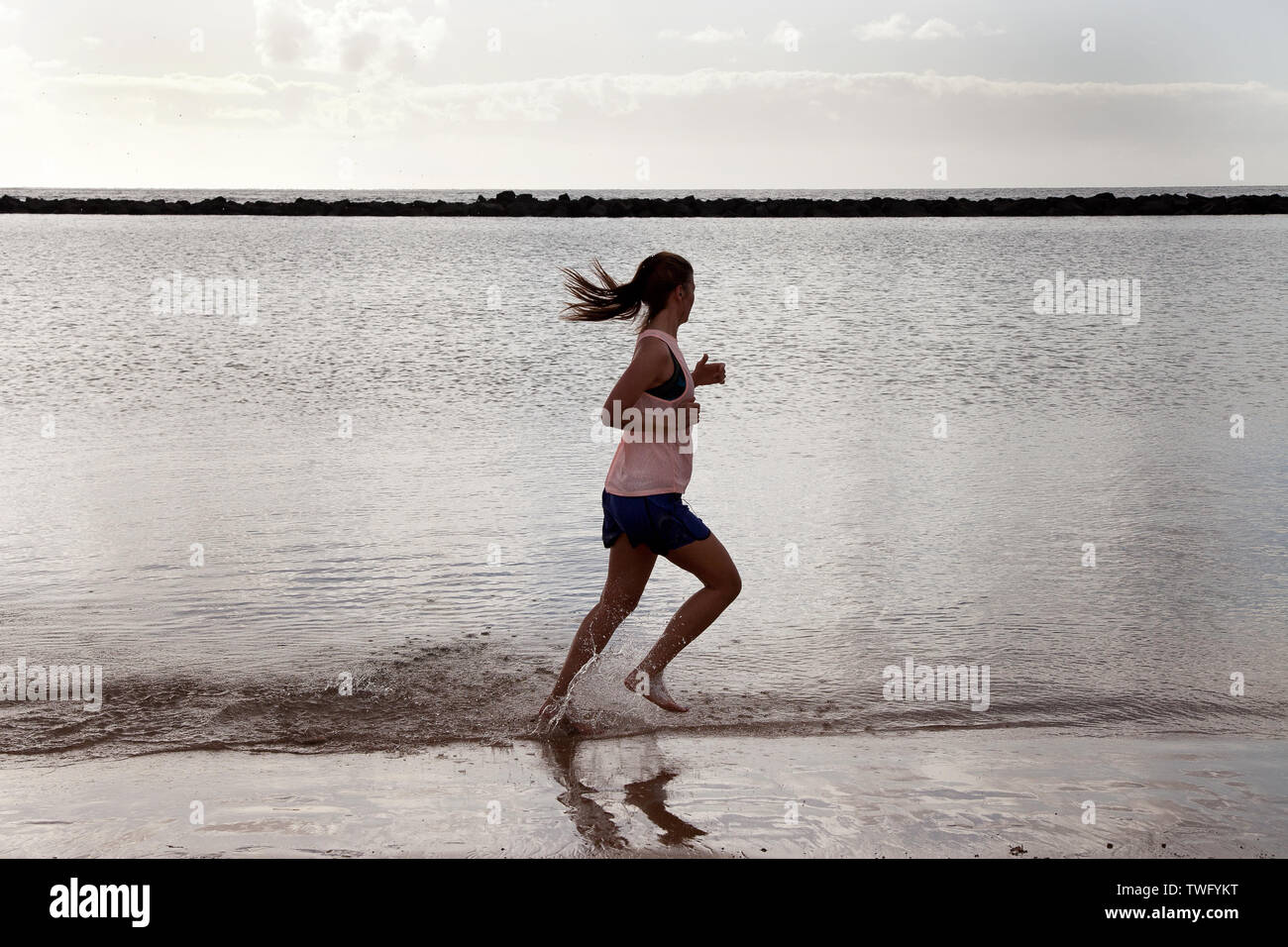 Woman running on beach, Tenerife, Canary Islands, Spain Stock Photo - Alamy