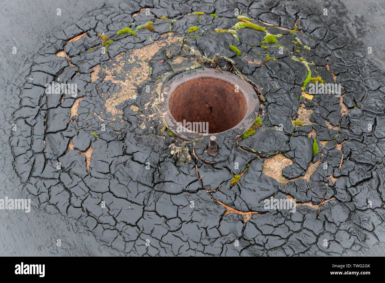 texture of cracked asphalt on a highway in the middle of a buried iron ...
