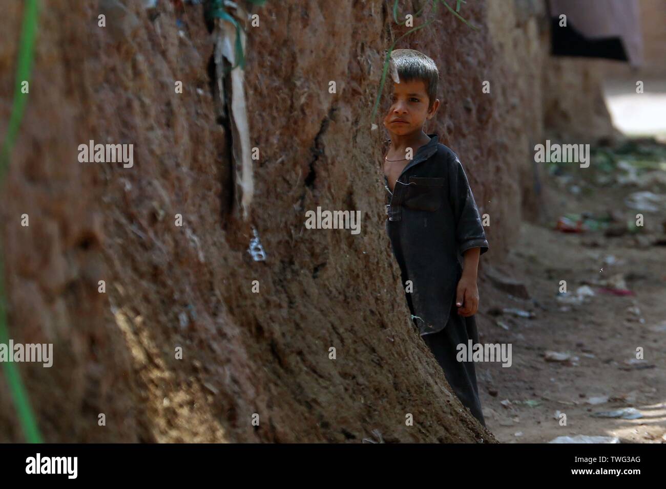 Islamabad. 20th June, 2019. An Afghan refugee boy stands beside his ...