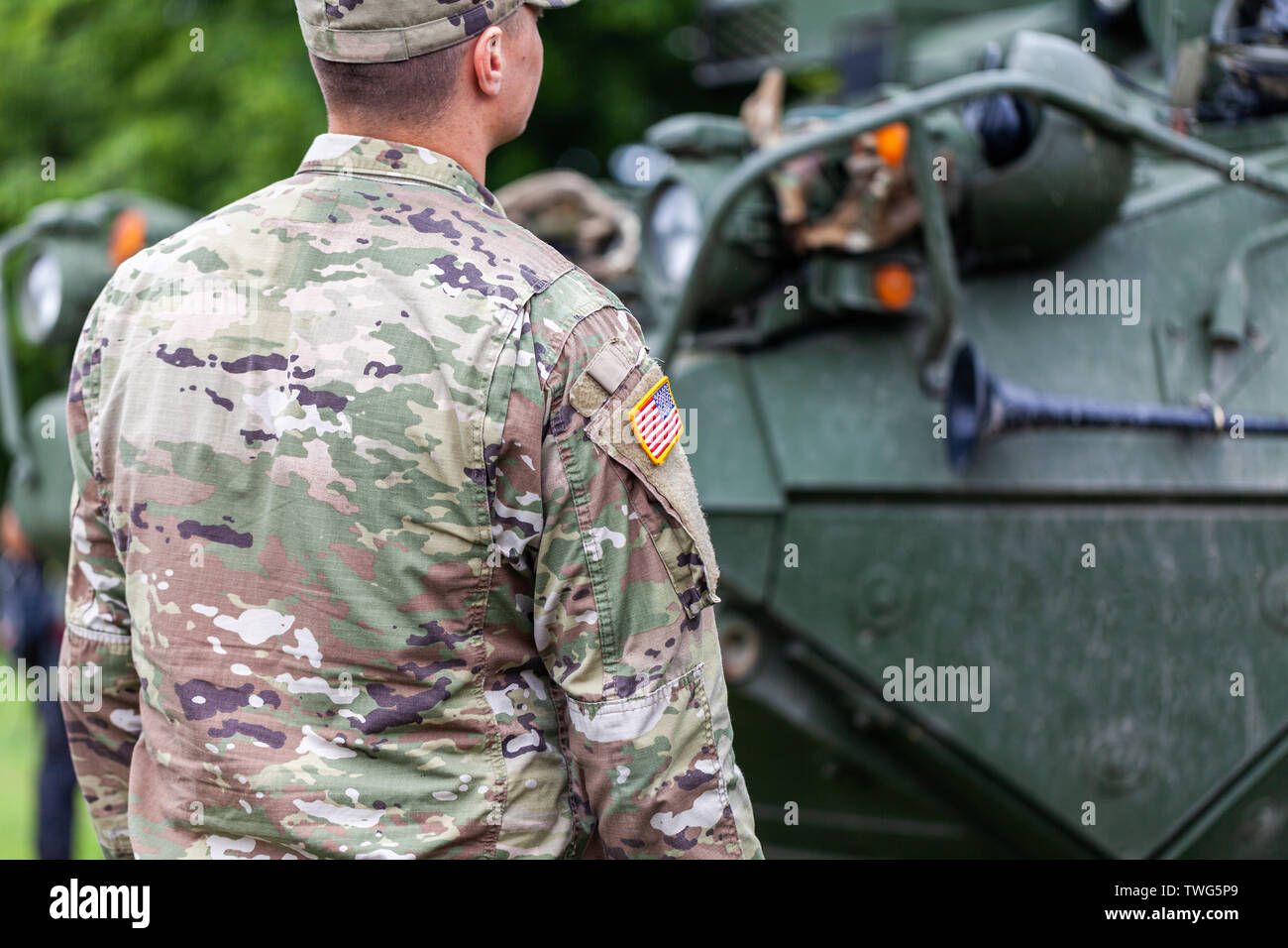A soldier from the united states army stands in front of an armored ...