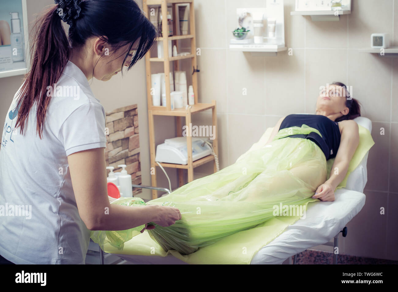 Young woman in beauty salon being prepared for vacuum body anti ...