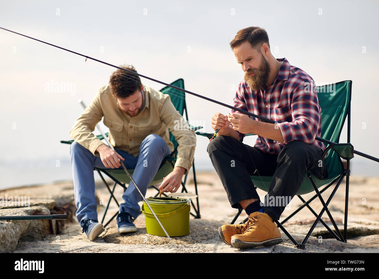 Man sitting on bucket fishing hi-res stock photography and images - Alamy