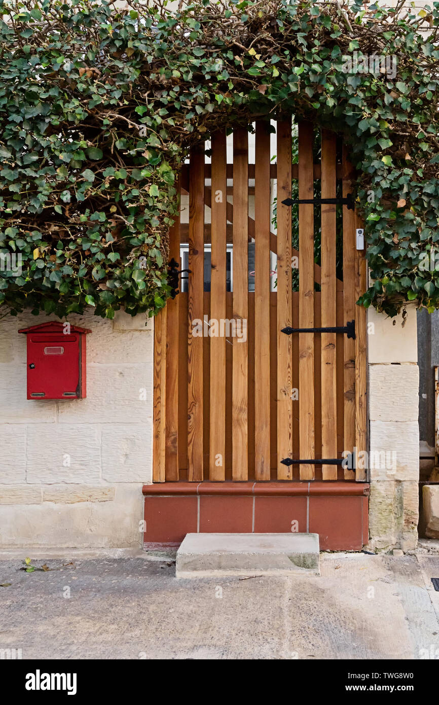 Cozy wooden front door with arch from bush at the entrance of ...