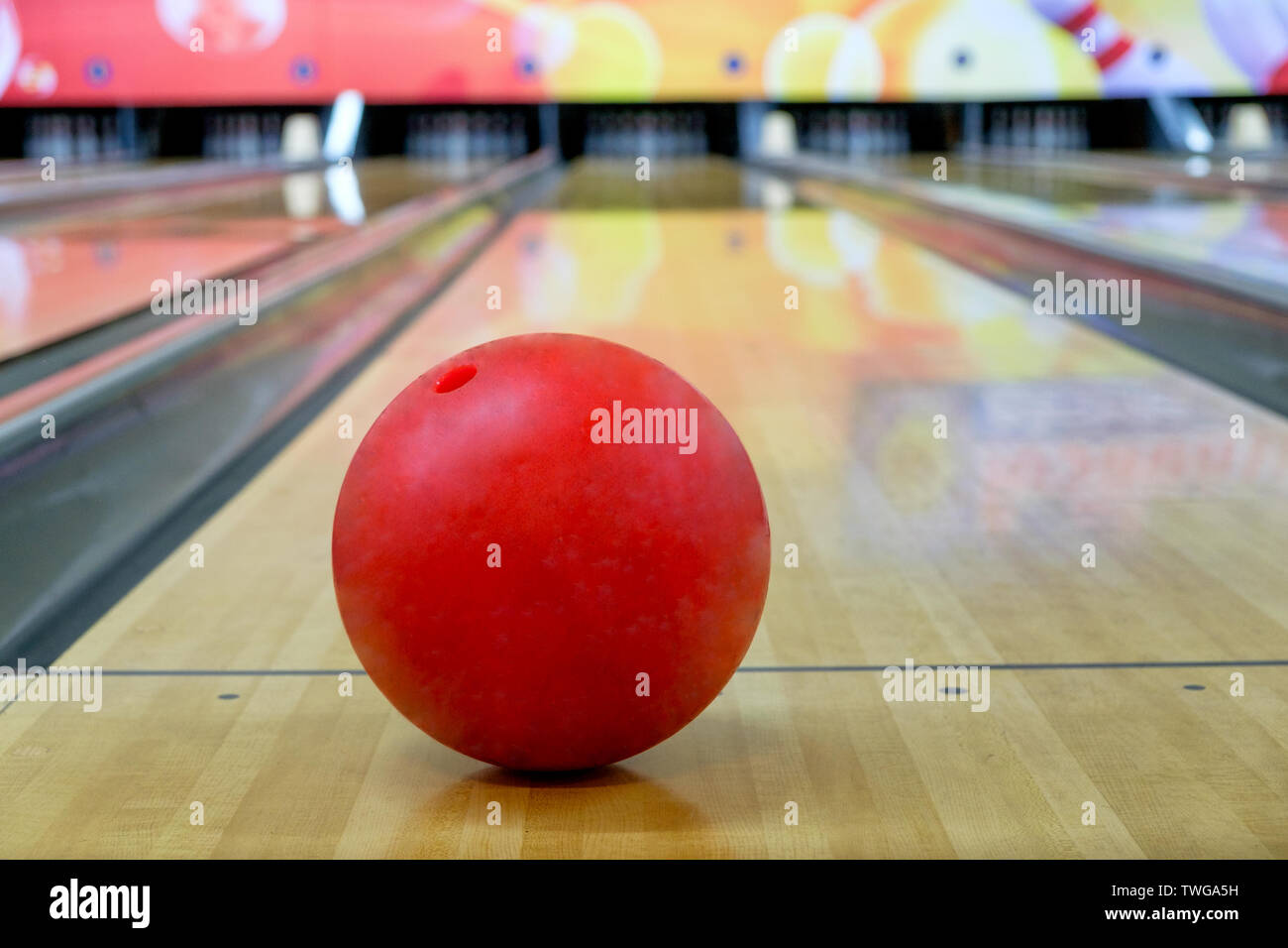 Red bowling ball put on wood alley with blurred bowling pin background ...