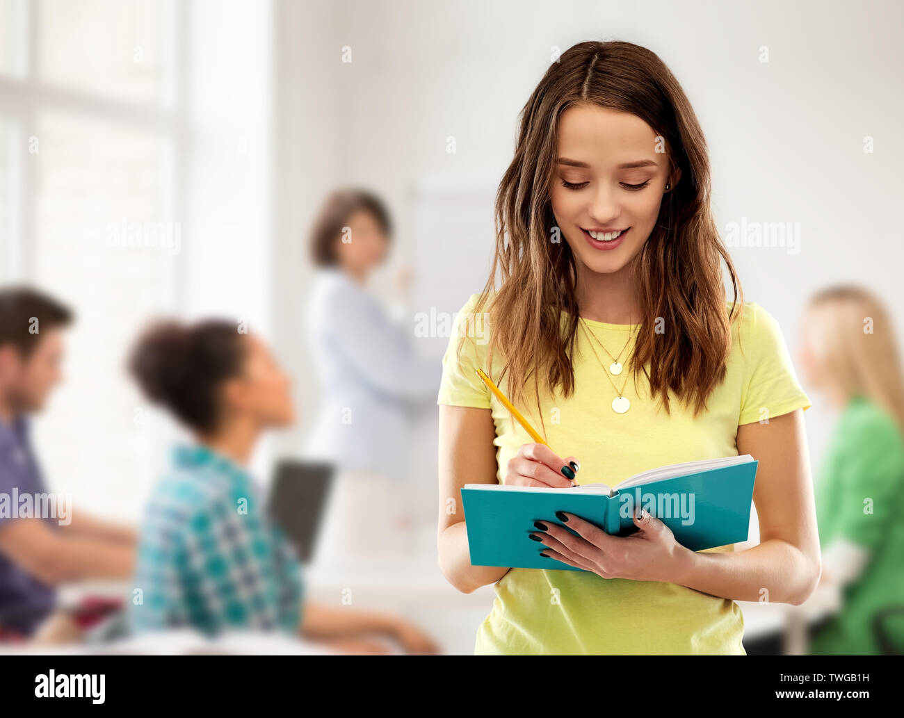 teenage student girl writing to notebook at school Stock Photo - Alamy