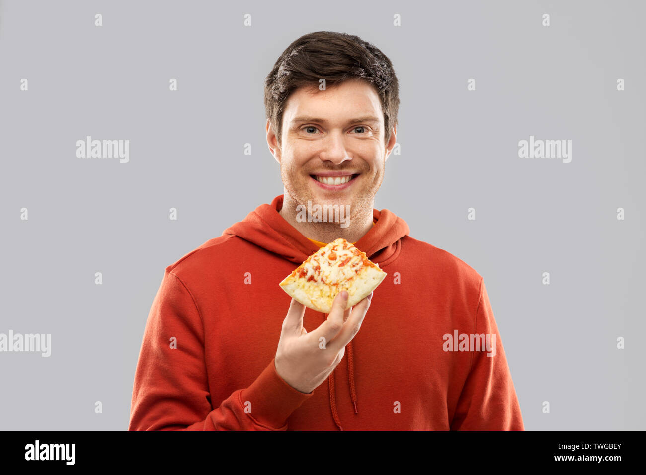 happy young man eating pizza Stock Photo - Alamy