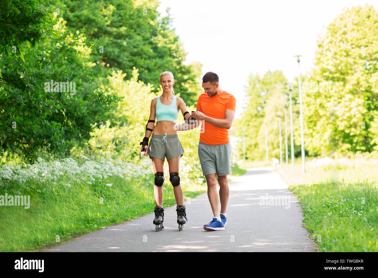 couple with roller skates riding in summer park Stock Photo - Alamy