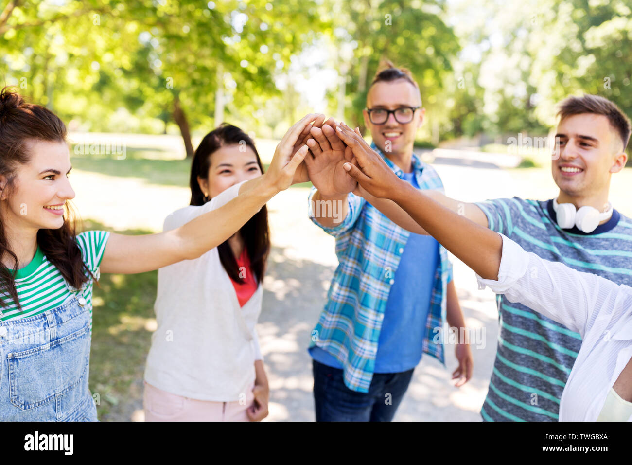 happy friends making high five in park Stock Photo - Alamy