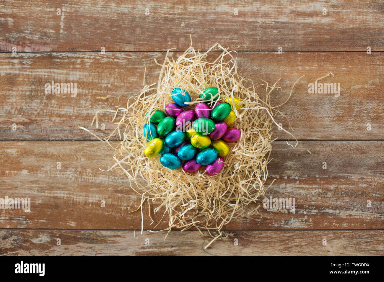chocolate eggs in foil wrappers in straw nest Stock Photo - Alamy