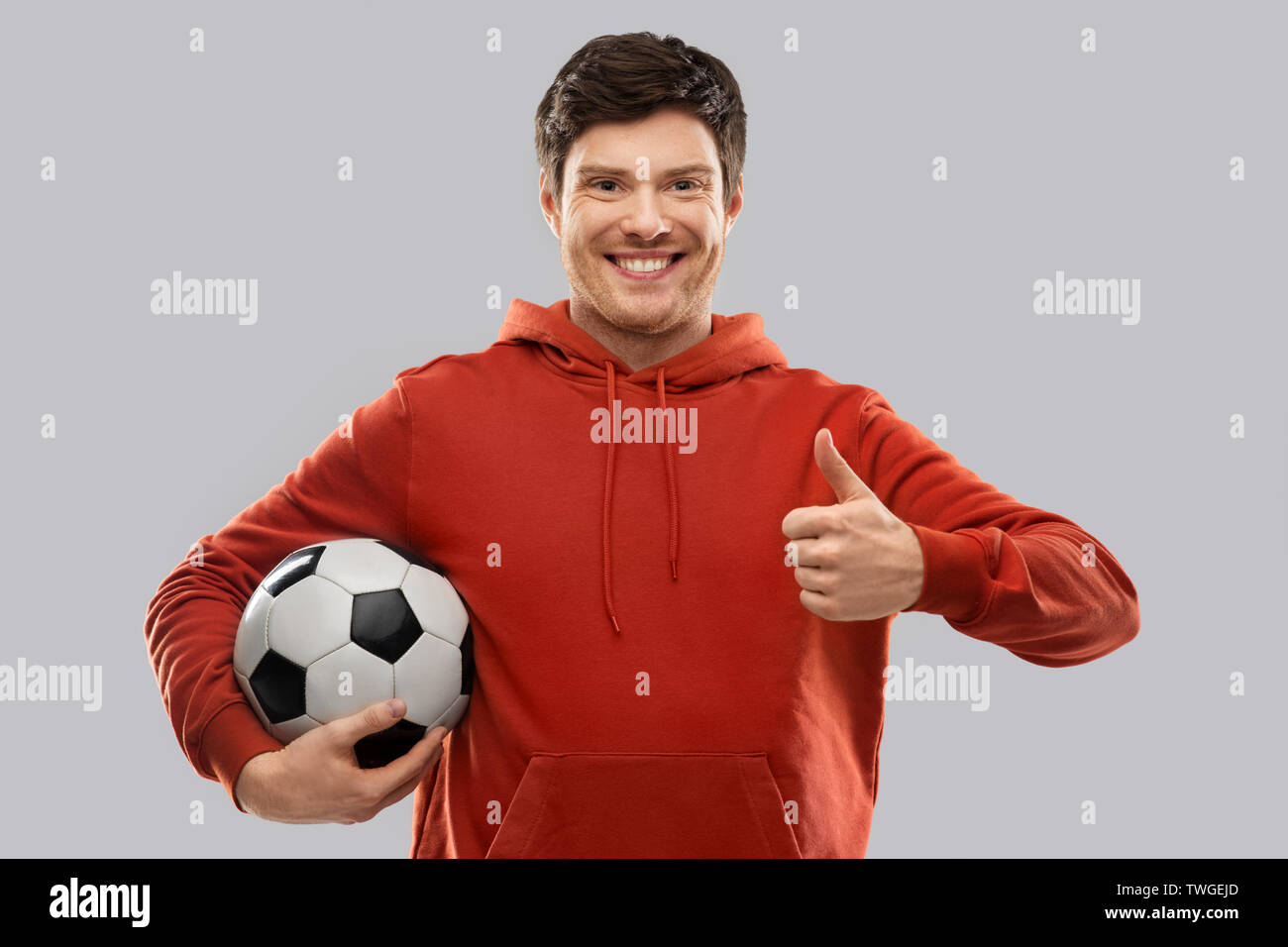 male football fan with soccer ball shows thumbs up Stock Photo - Alamy