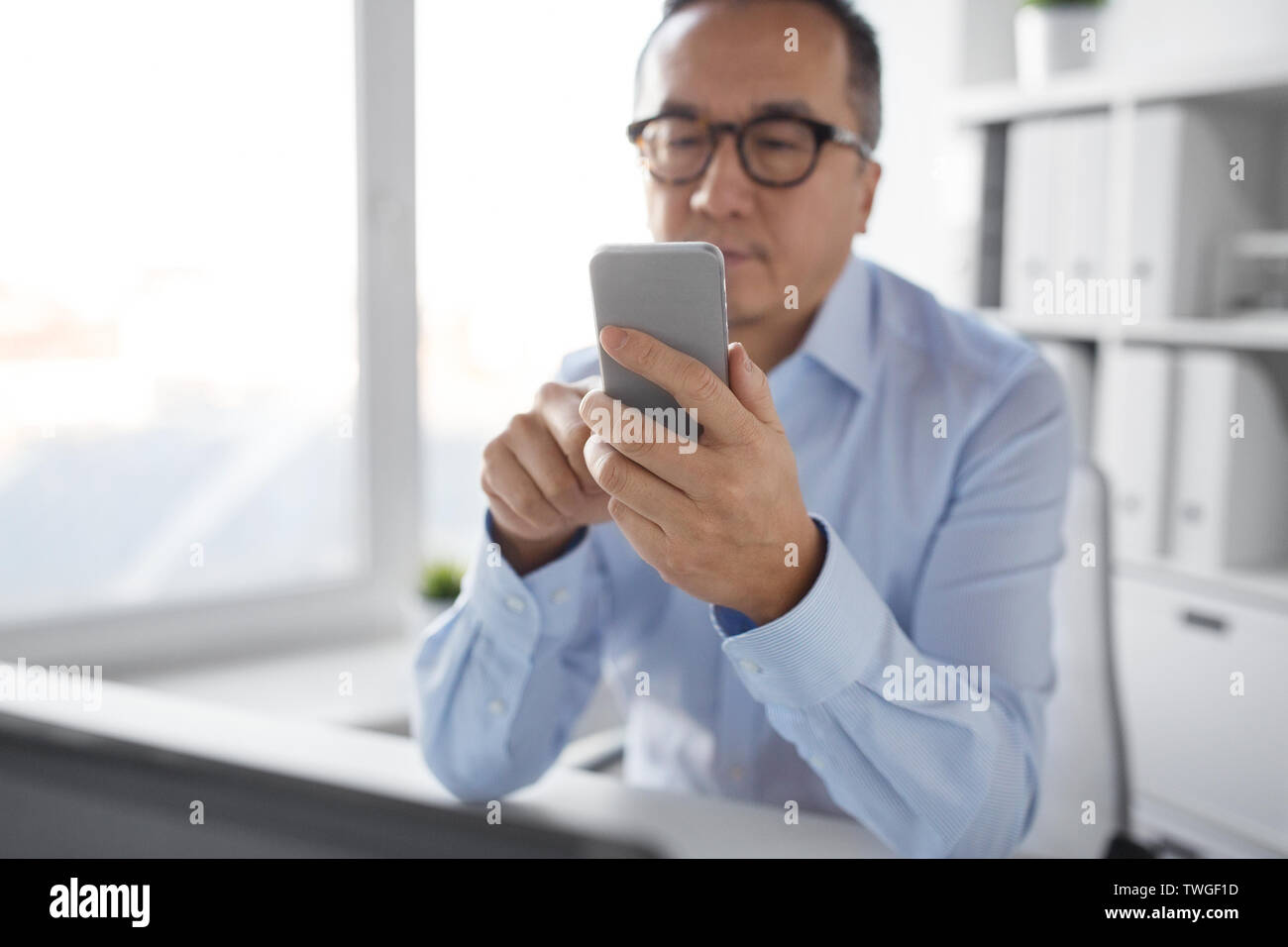 Asian office worker using smartphone hi-res stock photography and ...