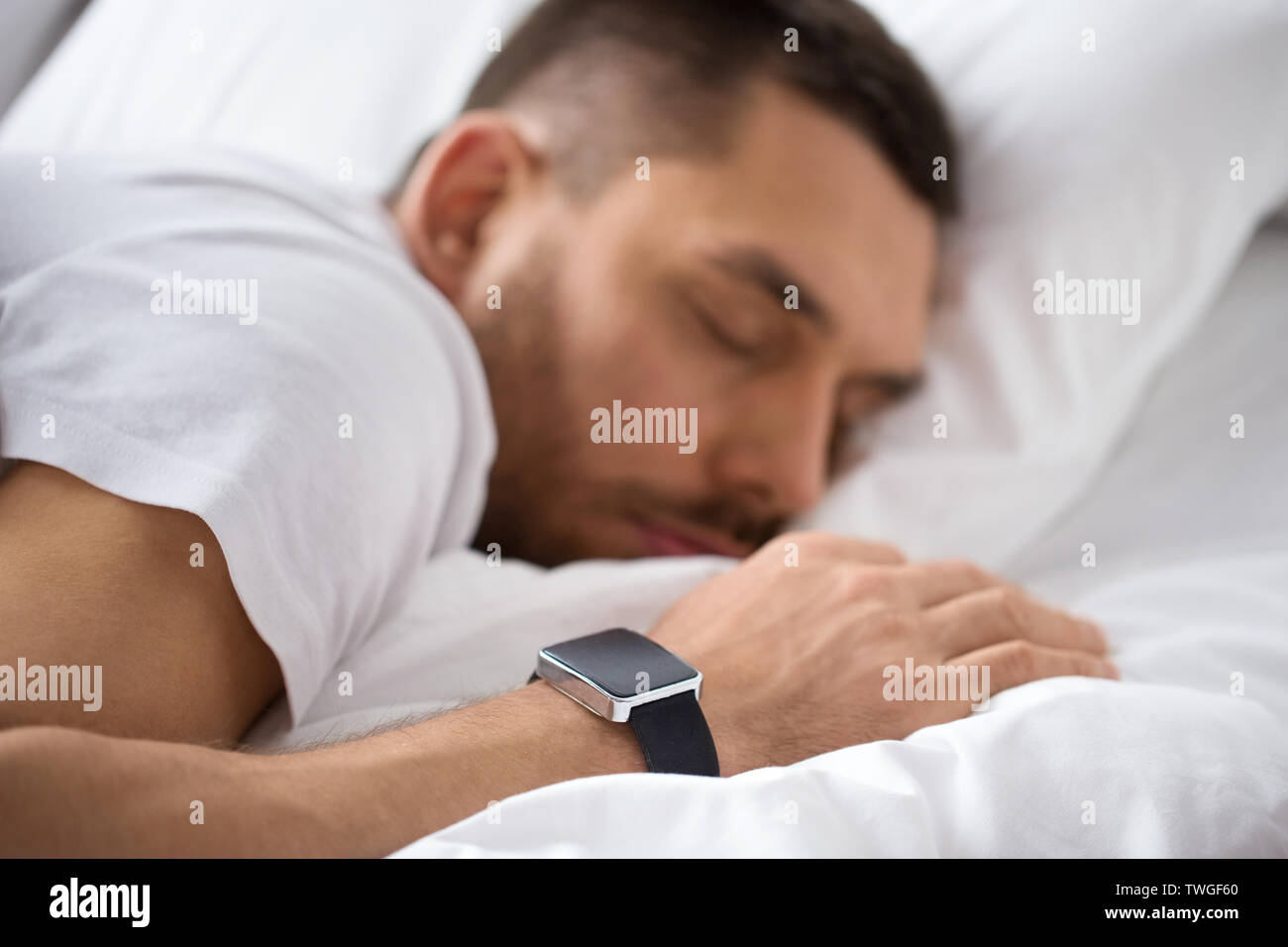 close up of man with smart watch sleeping in bed Stock Photo - Alamy
