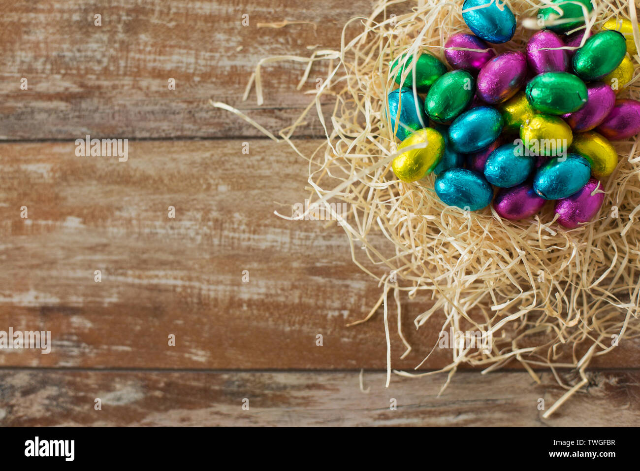 chocolate eggs in foil wrappers in straw nest Stock Photo - Alamy