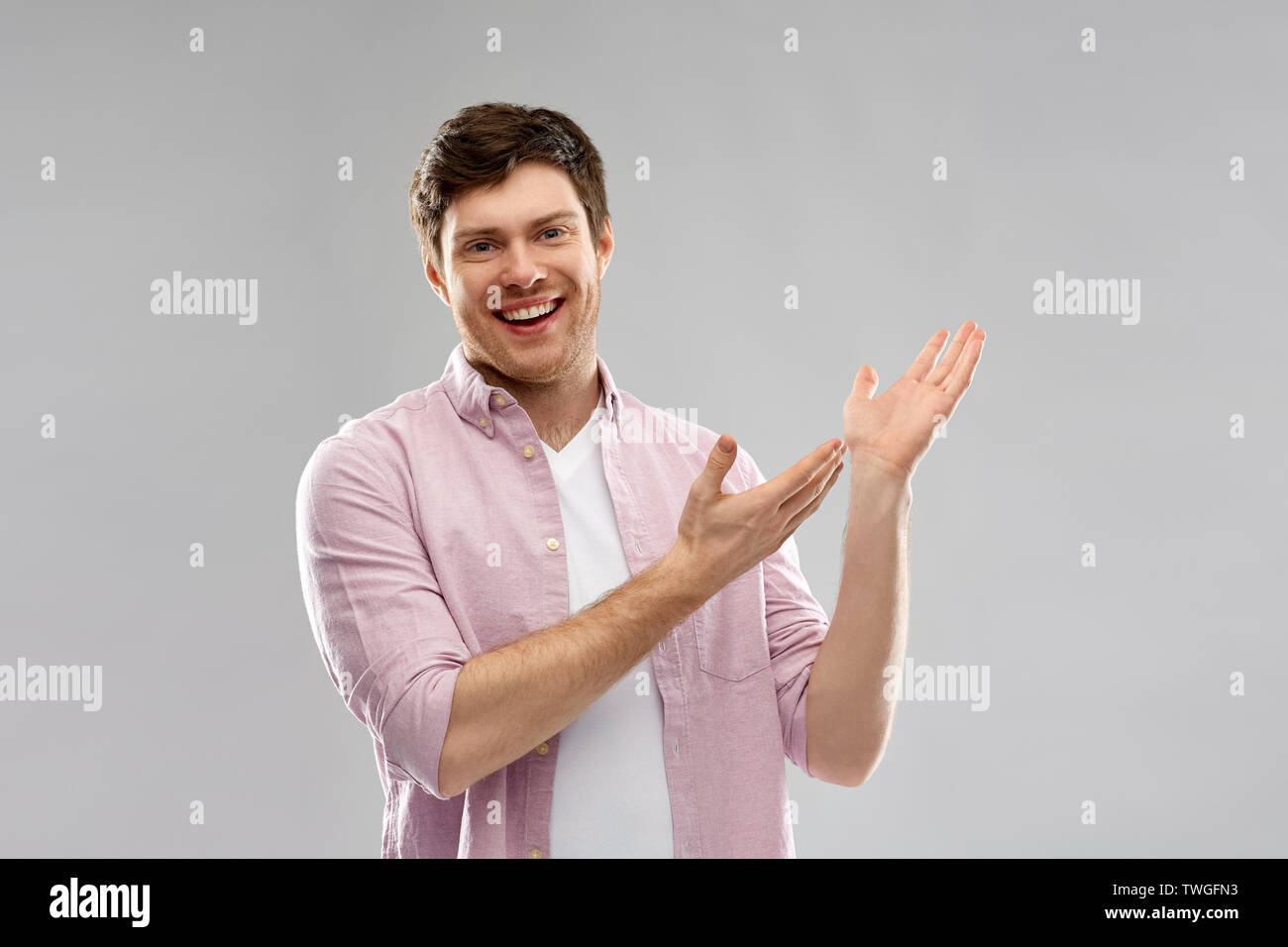 smiling young man showing something Stock Photo - Alamy