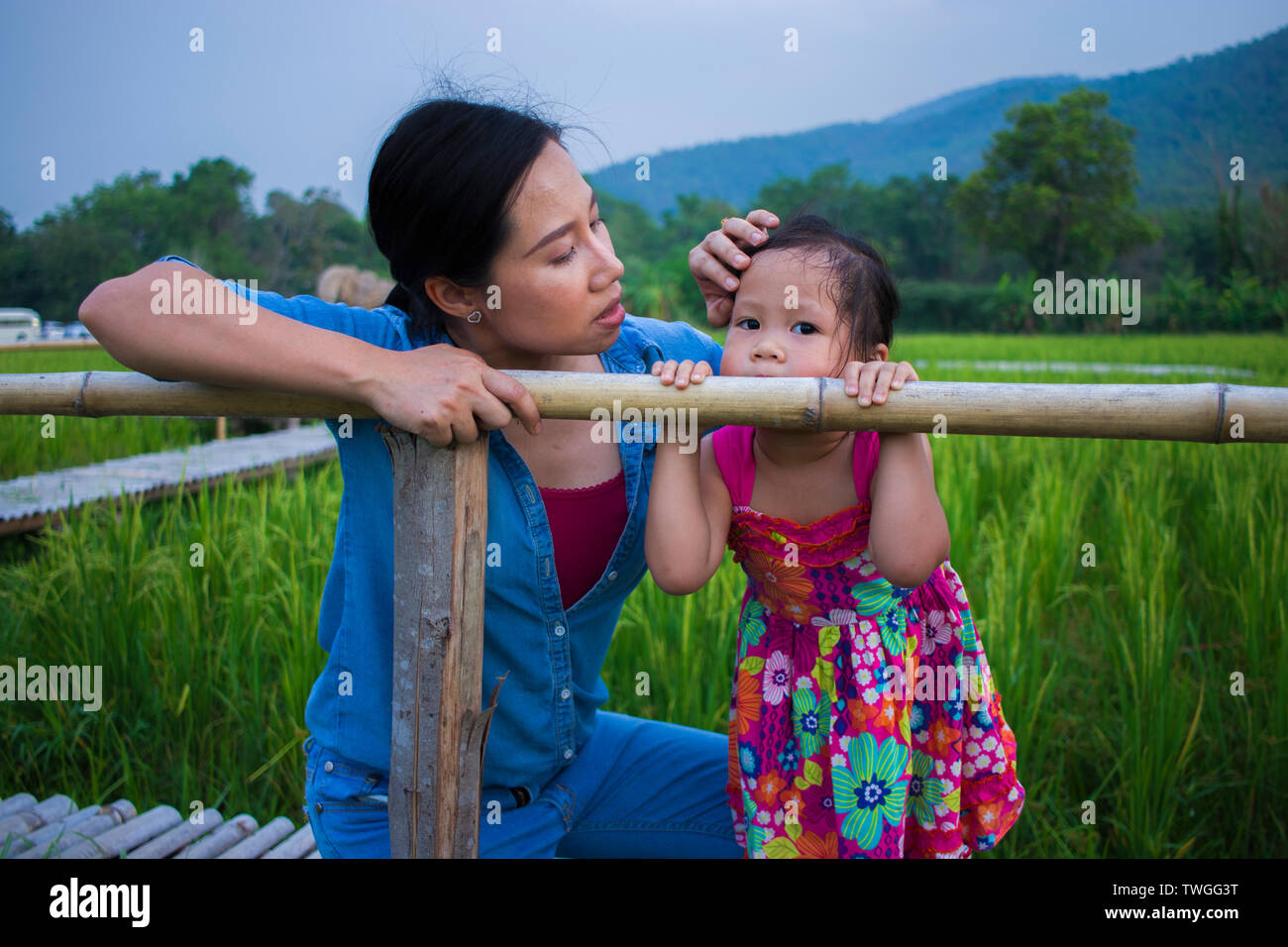 Young mother hugging and soothing a crying little daughter, Asian ...