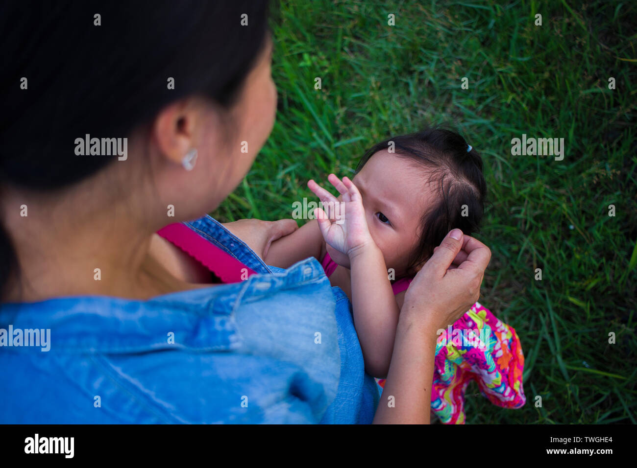 Young mother hugging and soothing a crying little daughter, Asian ... Young mother hugging and soothing a crying little daughter, Asian ...