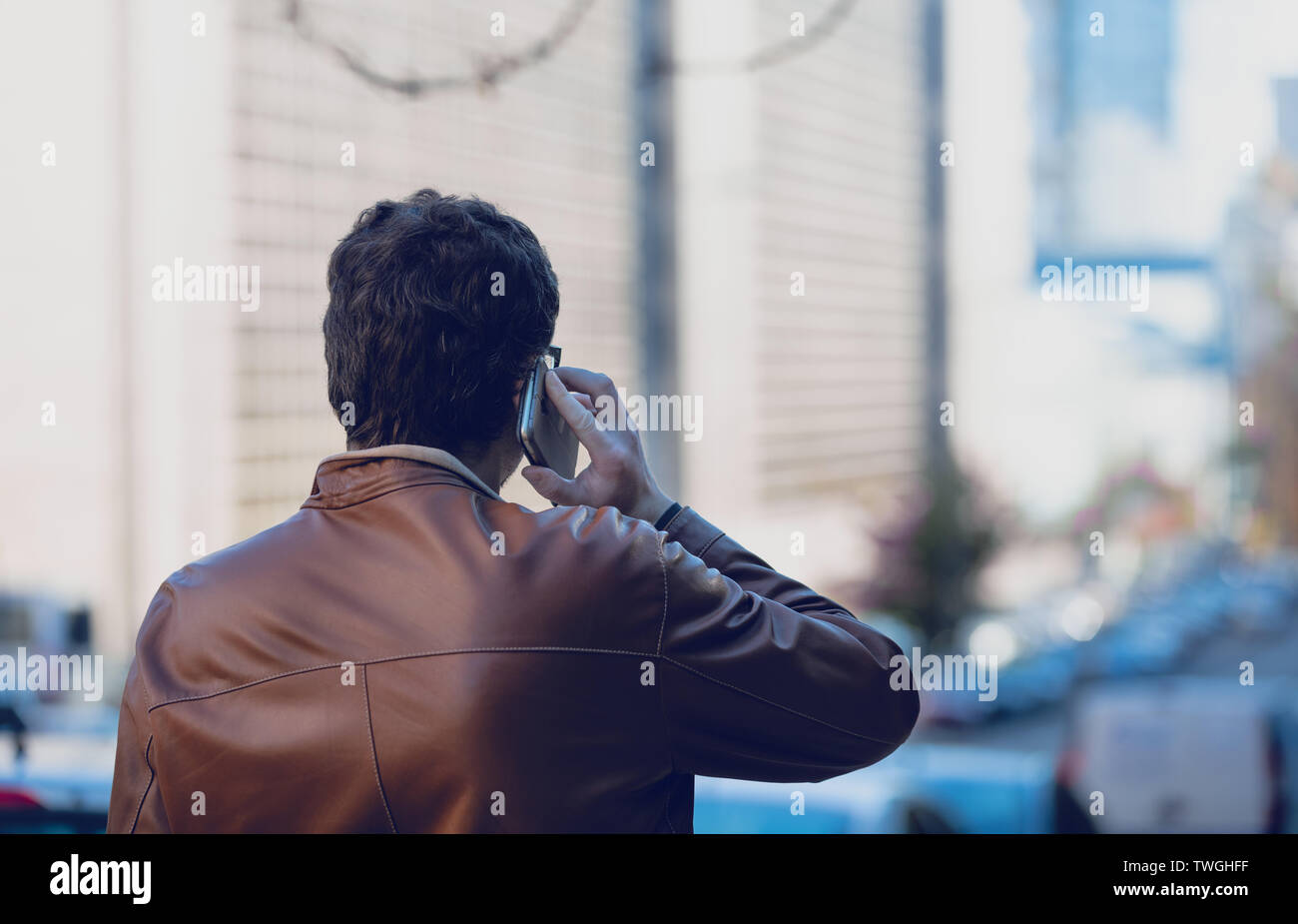 Back view portrait of businessman with smartphone, making a phone call ...