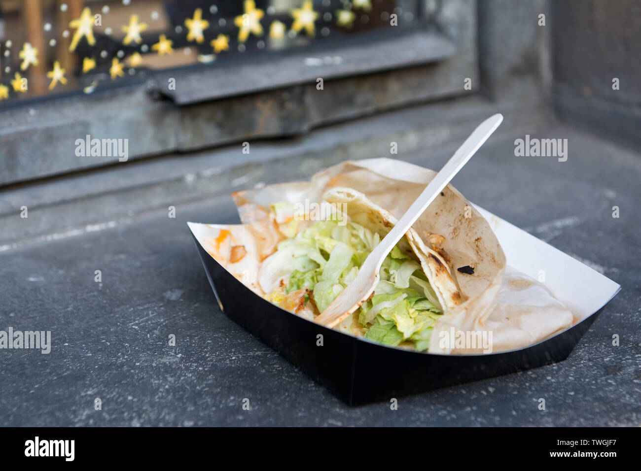 cardboard foof tray with left over food and disposable wooden fork ...