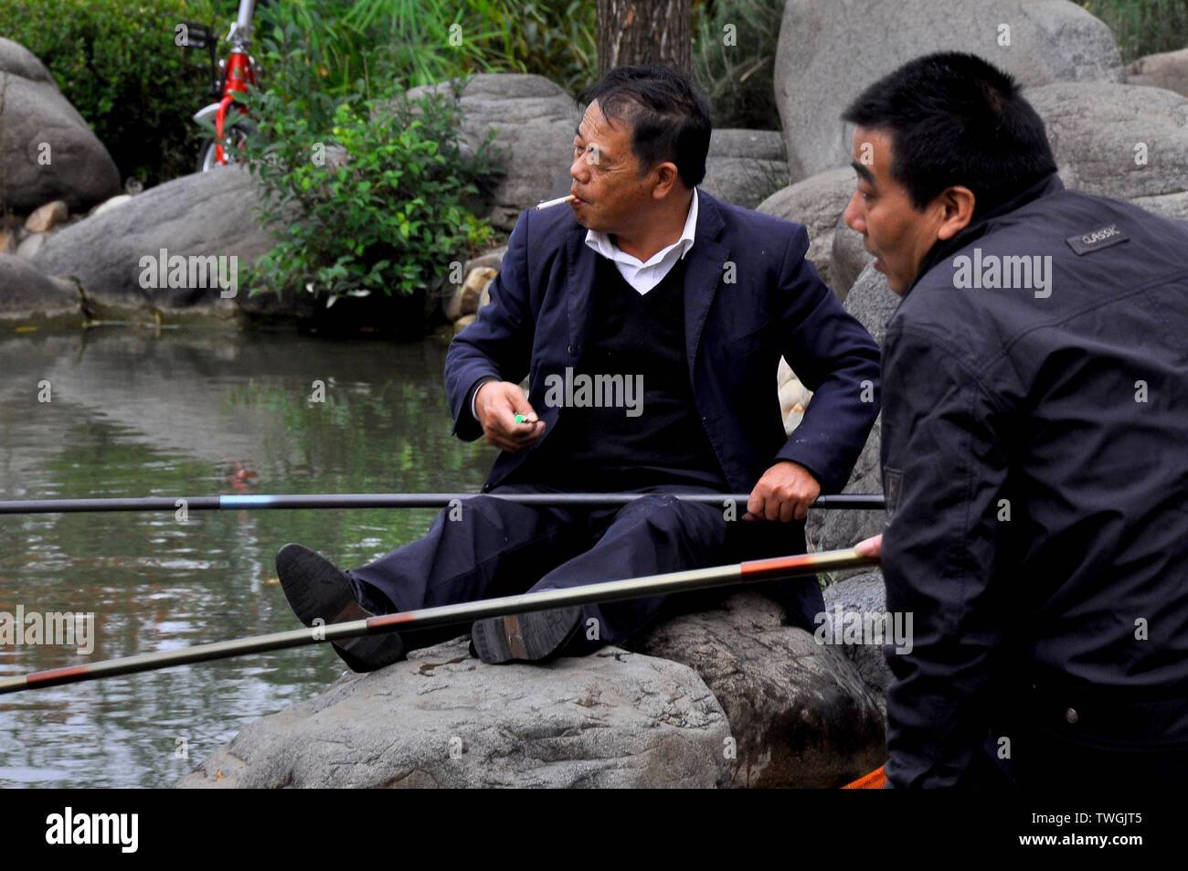 Two Chinese man fish in a Shanghai park Stock Photo - Alamy