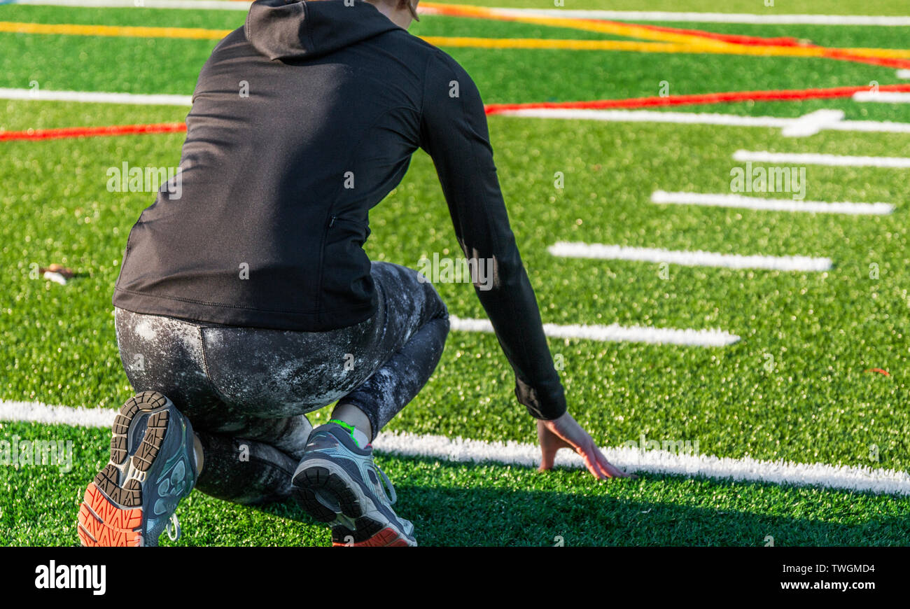 High school girl is in the on your mark position as she is practicing ...