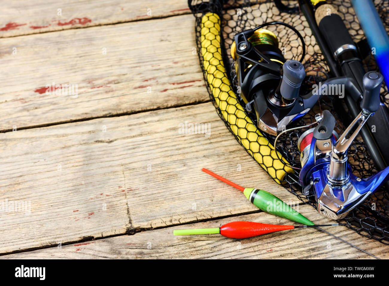 Fishing rods and reels with line on wooden background with free space ...