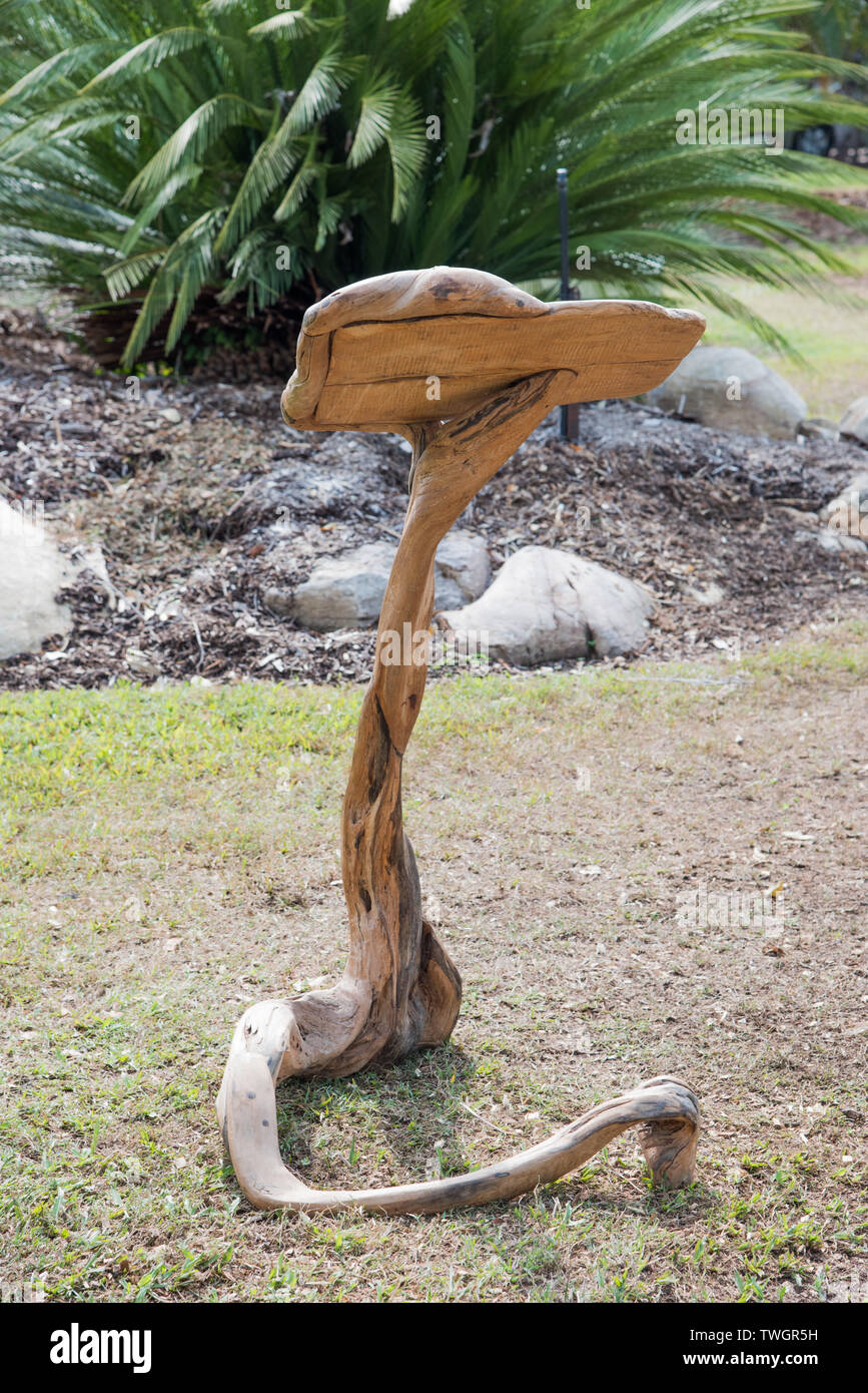Isolated wooden carved lectern stand in garden setting in sunny Darwin ...