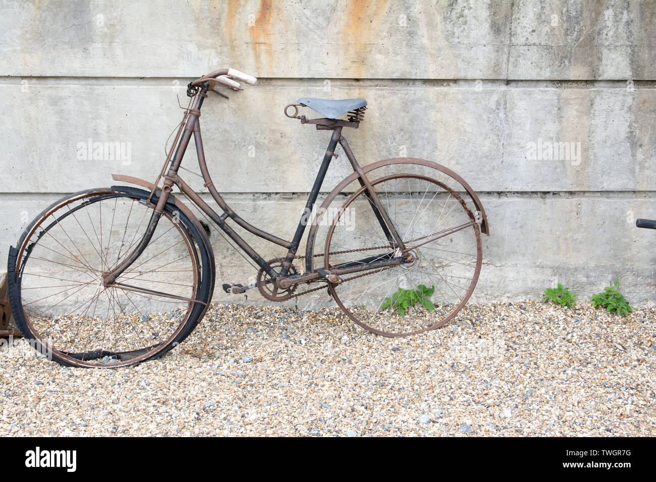 Rusting old bicycle leaning against a walll Stock Photo - Alamy