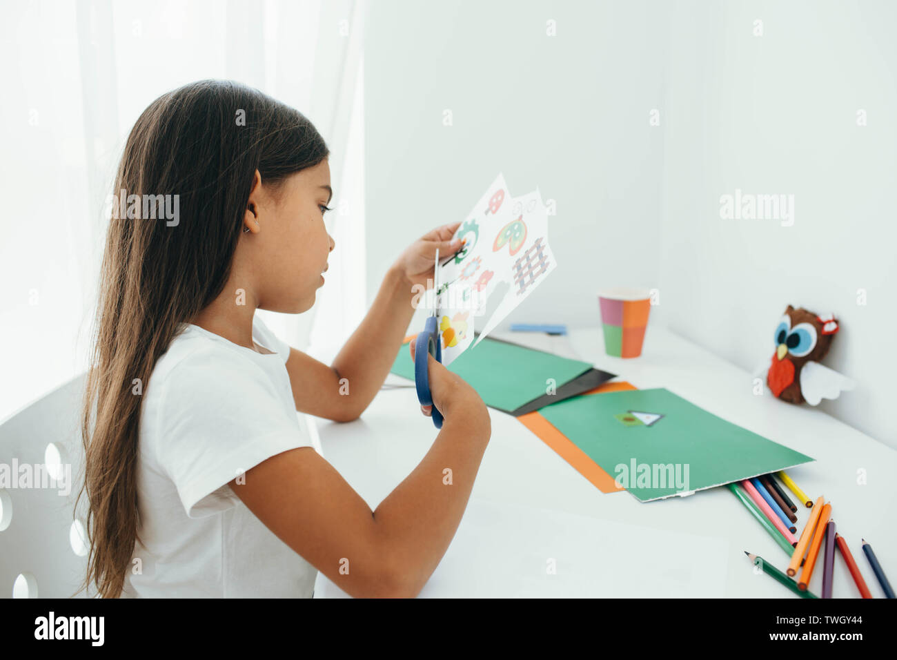 The girl cutting out of paper various pictures, children's leisure ...