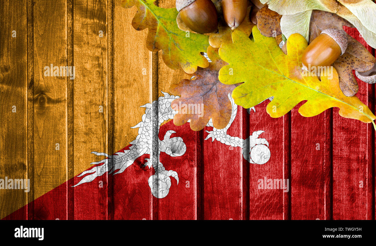 Butane flag on autumn wooden background with leaves and good place for ...