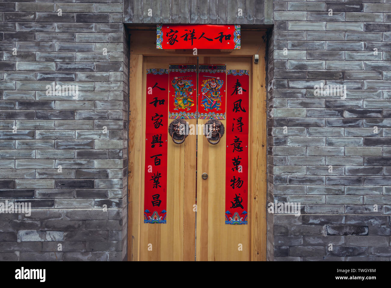 Wooden door to siheyuan courtyard in traditional hutong residential ...