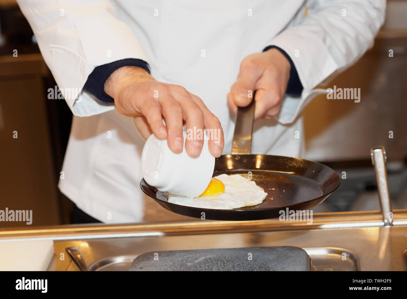Chef is frying eggs on pan at commercial kitchen Stock Photo - Alamy