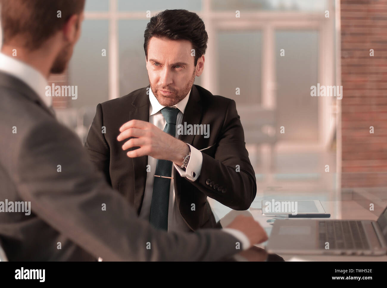 two businessmen sitting at the office table Stock Photo - Alamy
