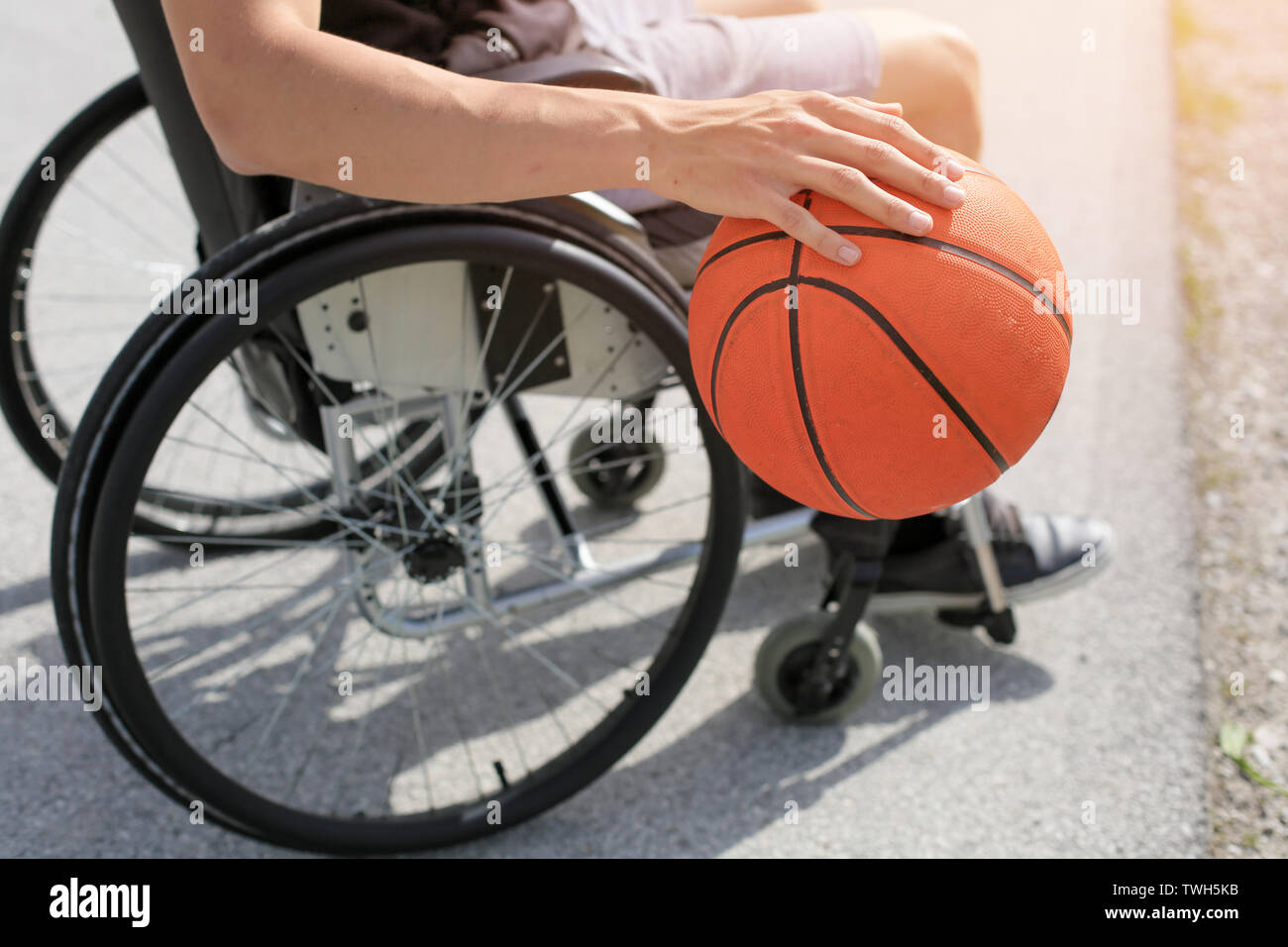 Disabled young basketball player on a wheelchair holding ball and ...