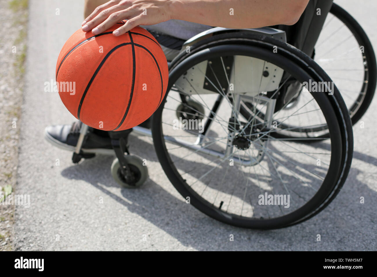 Disabled young basketball player on a wheelchair holding ball and ...