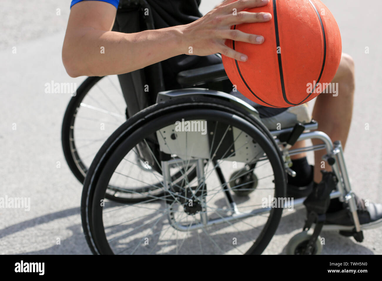 Disabled young basketball player on a wheelchair holding ball and ...