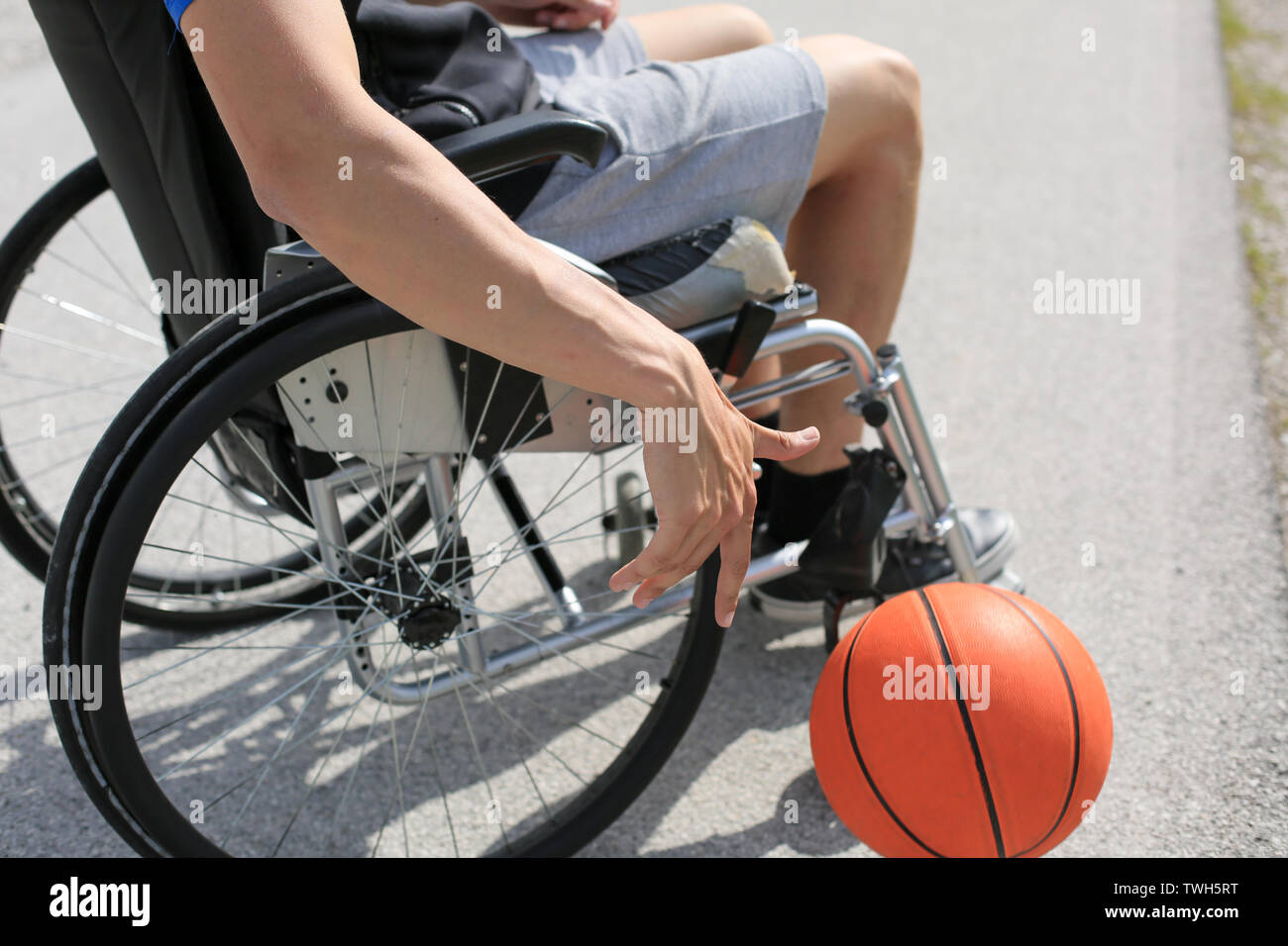 Disabled young basketball player on a wheelchair holding ball and ...