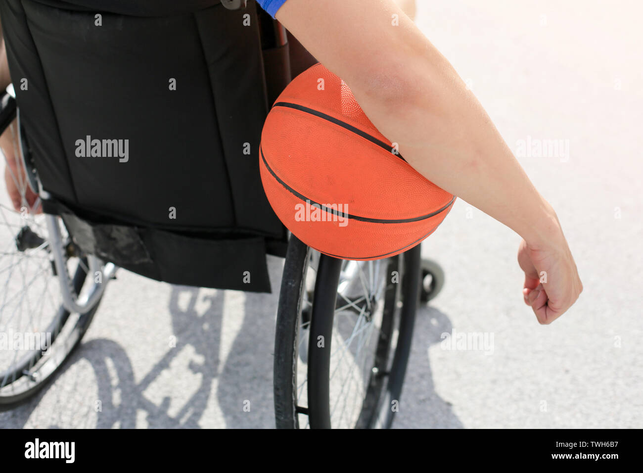 Disabled young basketball player on a wheelchair holding ball and ...