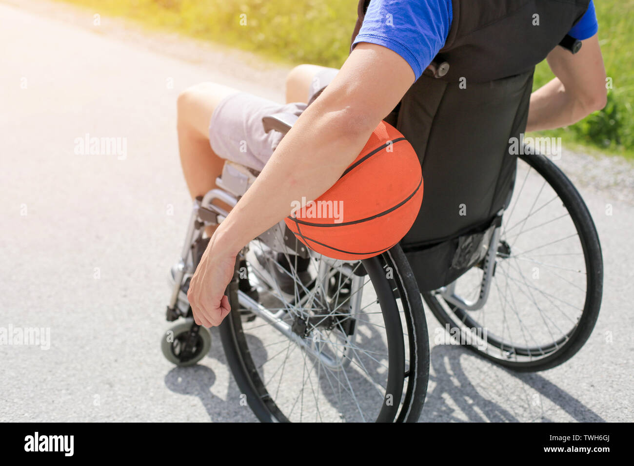 Disabled young basketball player on a wheelchair holding ball and ...