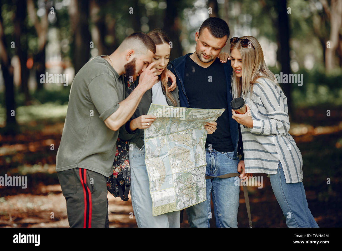 Four friends have a rest in a summer forest Stock Photo - Alamy
