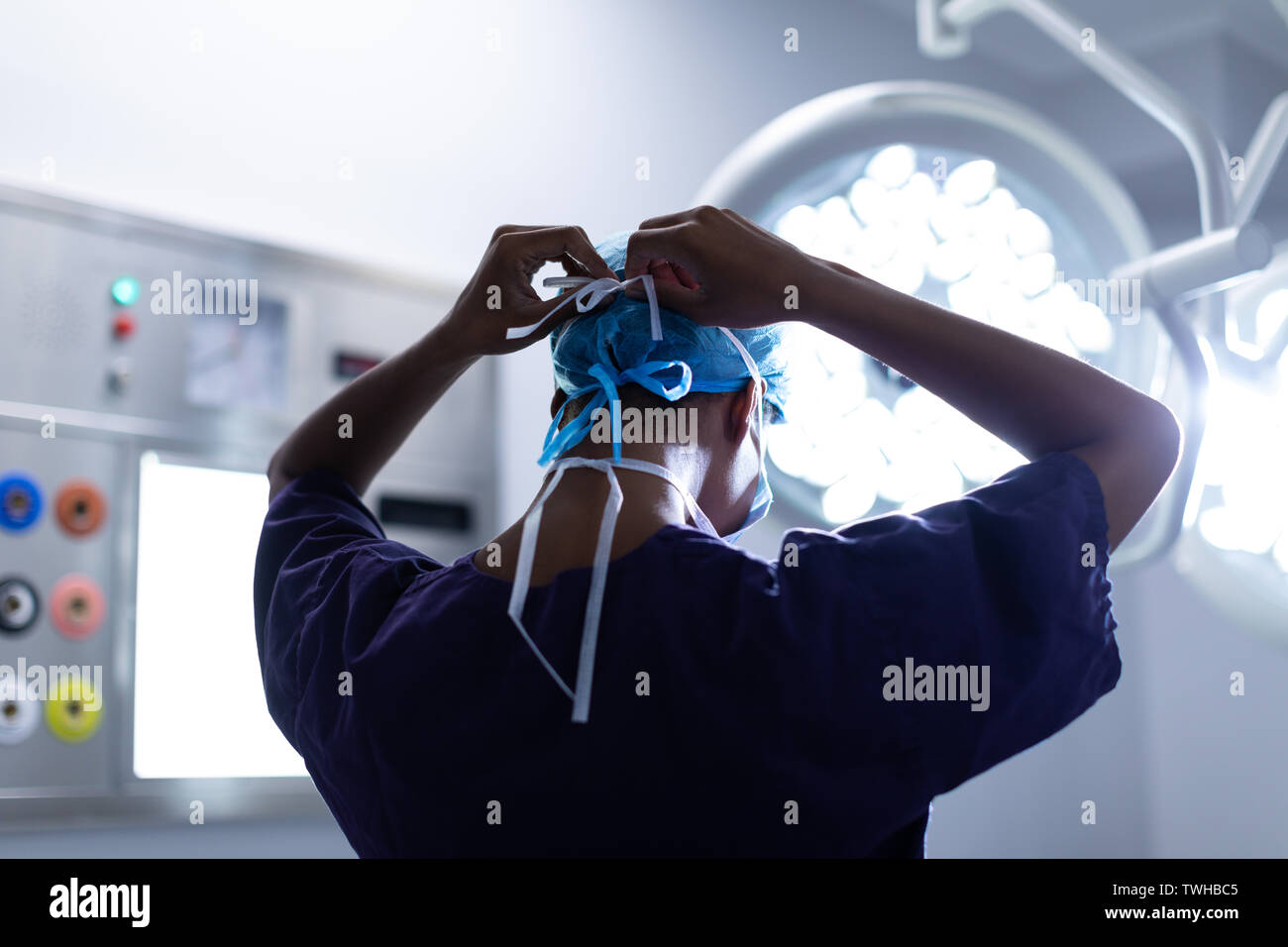 Female surgeon wearing surgical mask in operation theater at hospital ...