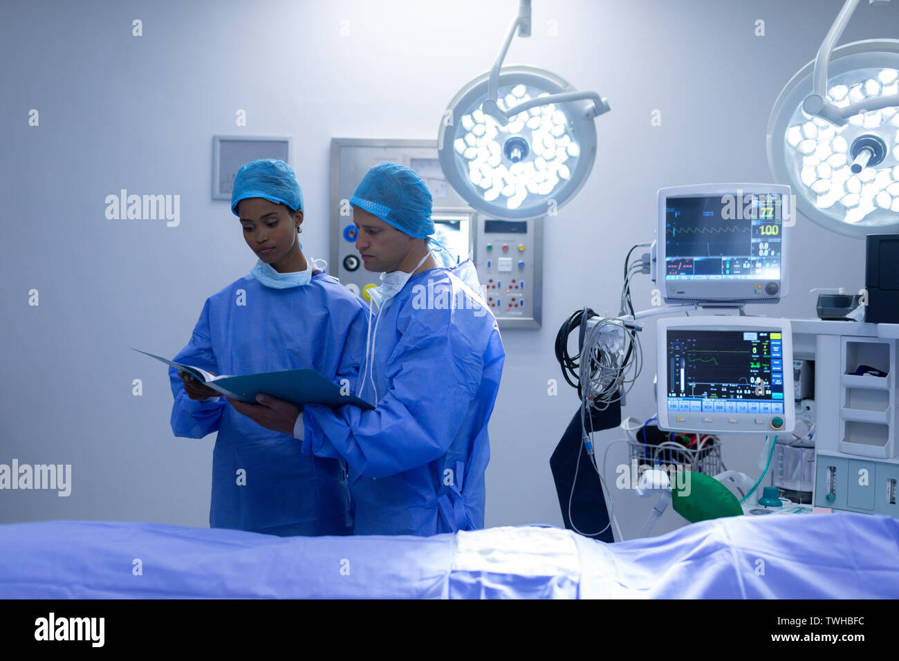Surgeons discussing over medical report in operation theater Stock ...