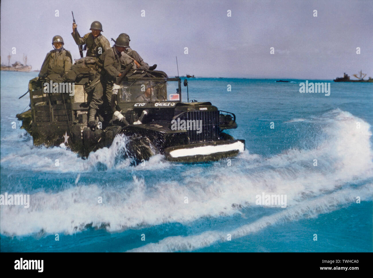 U.S. Military Truck with Soldiers driving through water toward shore ...