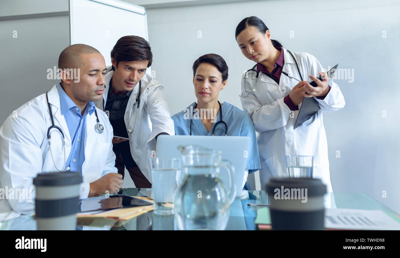 Medical team discussing over laptop at the table in hospital Stock ...