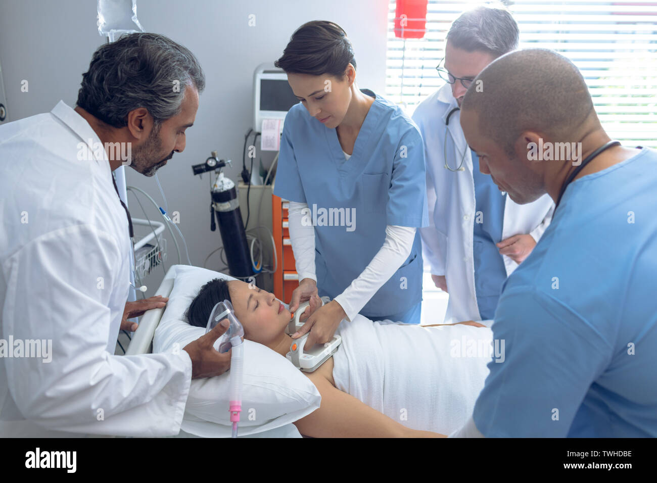 Doctors using defibrillator on patient in ward Stock Photo - Alamy