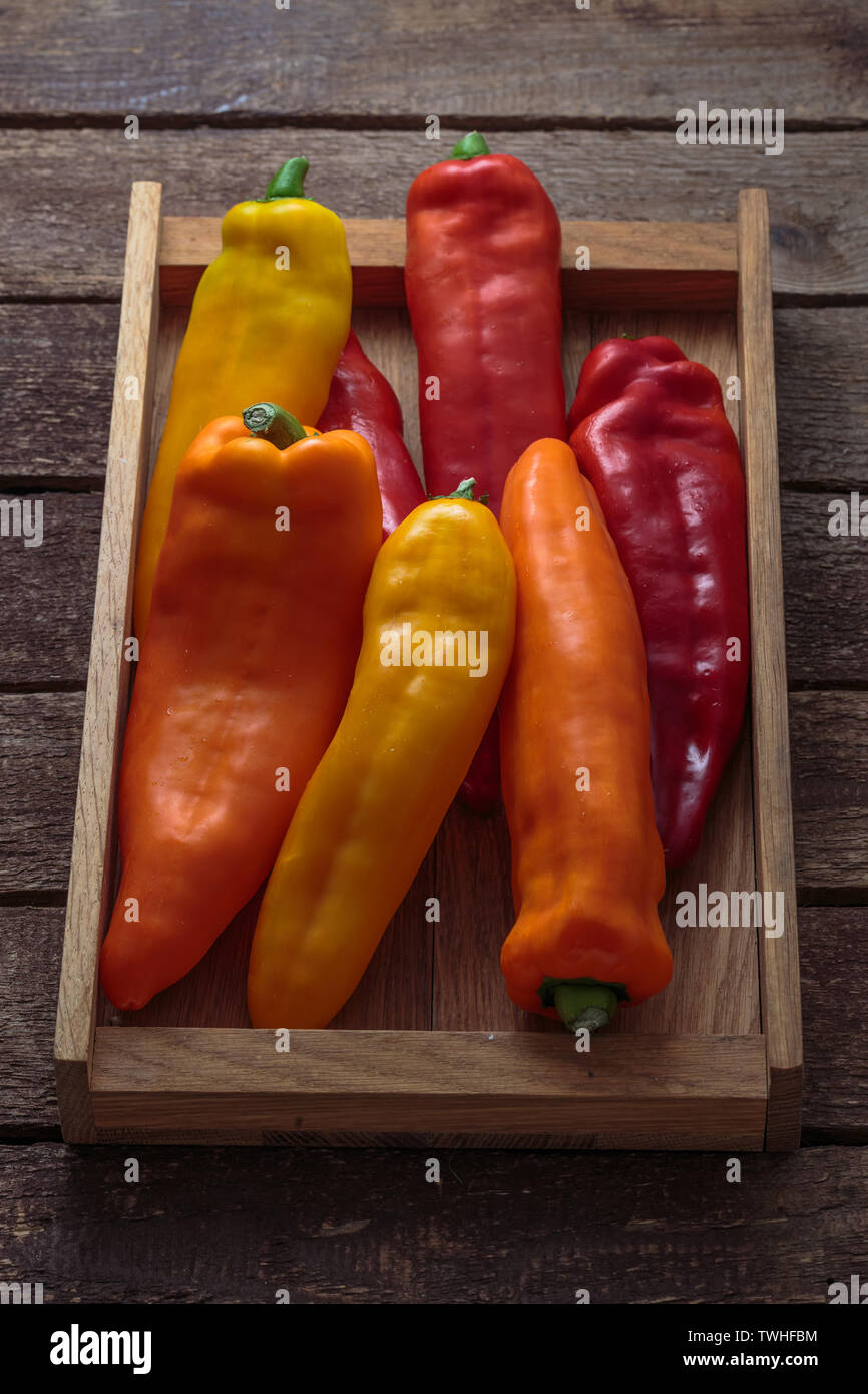 Close view colorful peppers in wooden box Stock Photo - Alamy