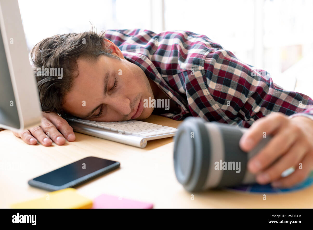 Male graphic designer sleeping on desk in a modern office Stock Photo ...