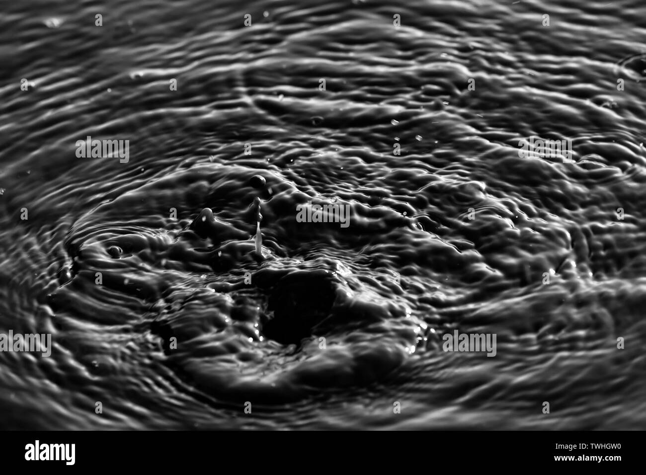 Black mud lagoon water, oily liquid, circles on the water, ripples on ...