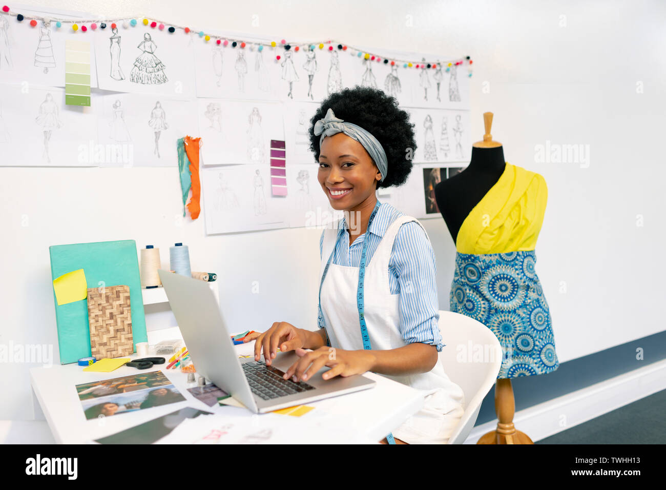 Female graphic designer using laptop in office Stock Photo - Alamy