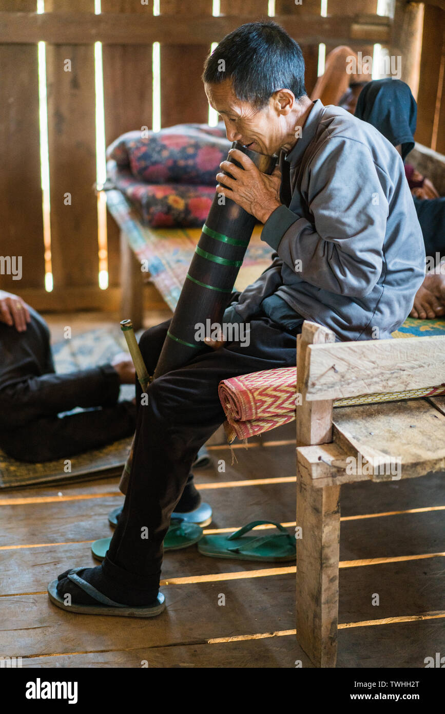 man smoking opium by traditional tobacco pipe in the akha Pixor village ...