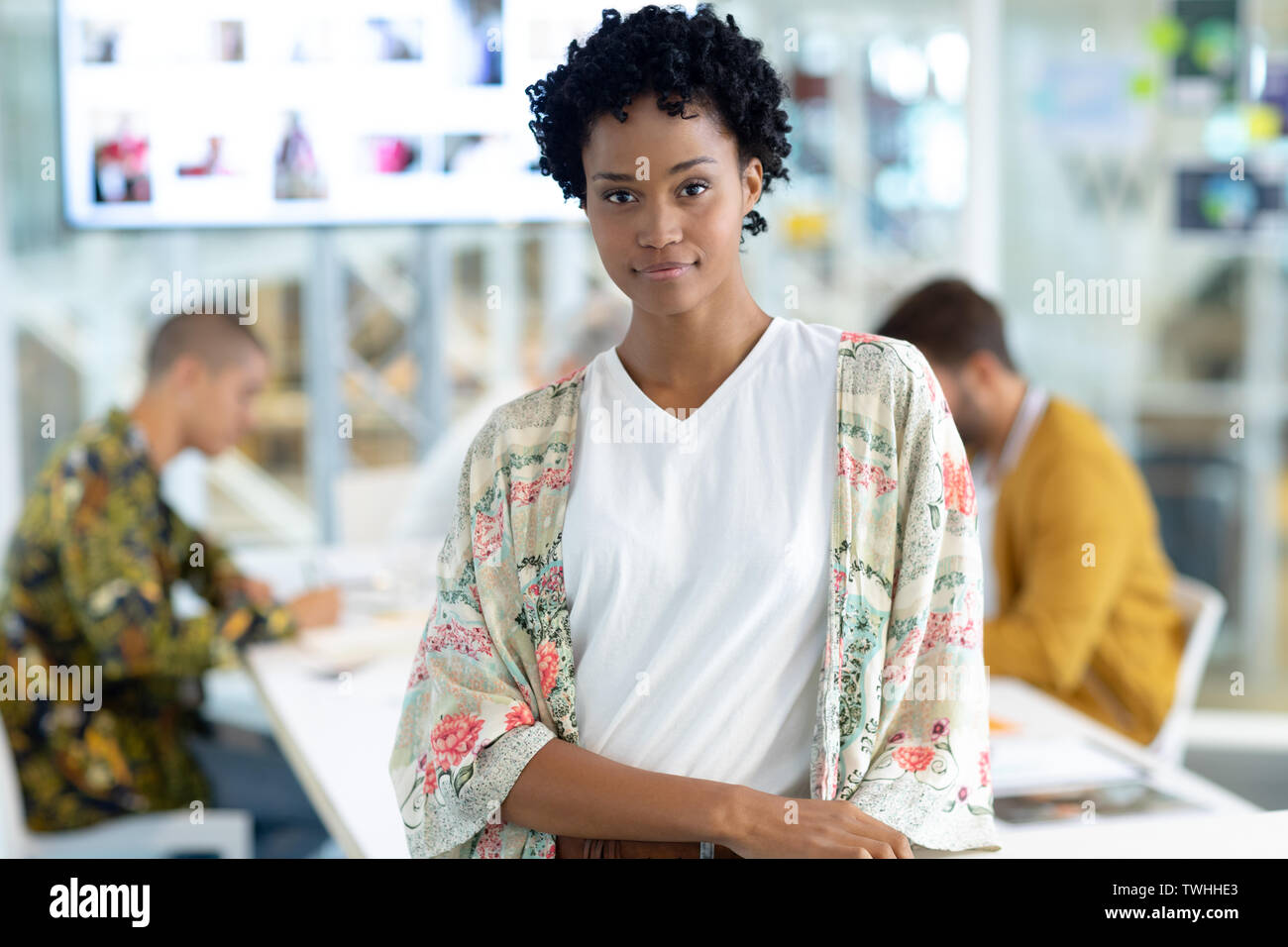 Female fashion designer leaning on a table at conference room in office ...